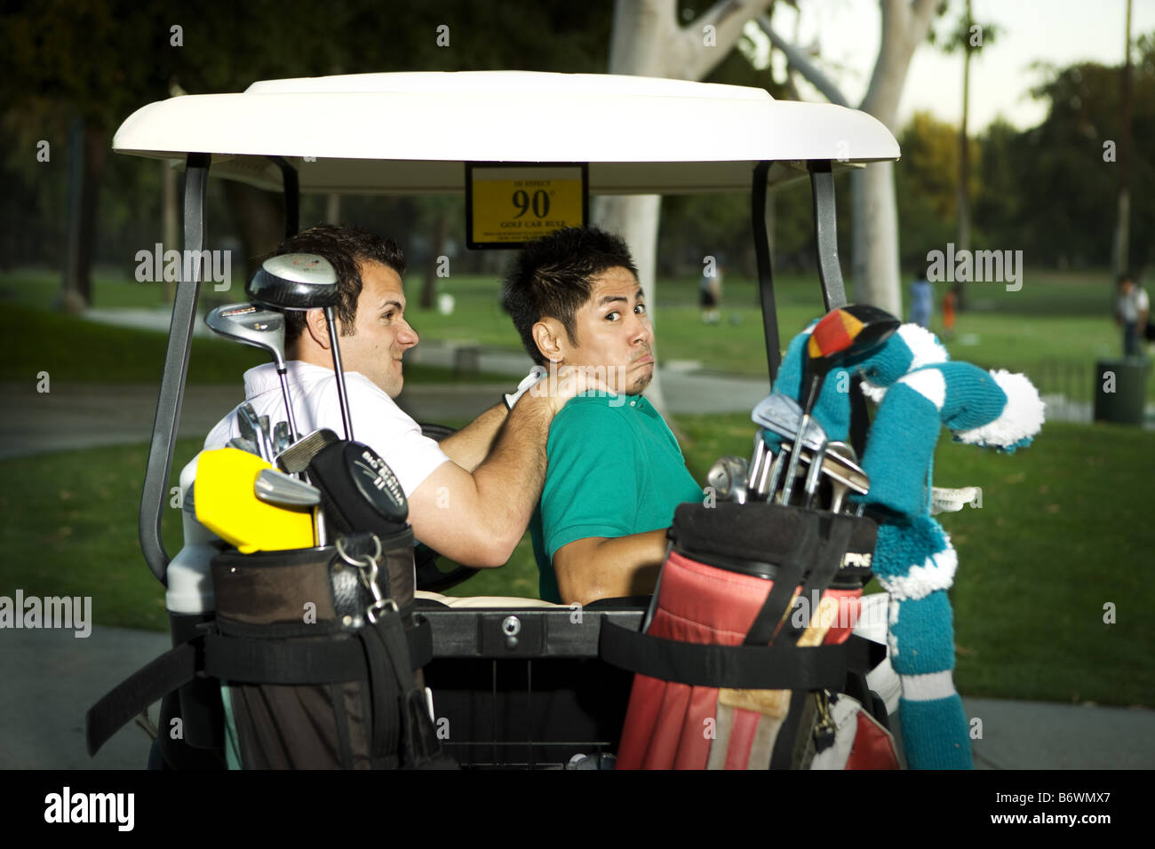 Two men having fun on golf cart Stock Photo - Alamy