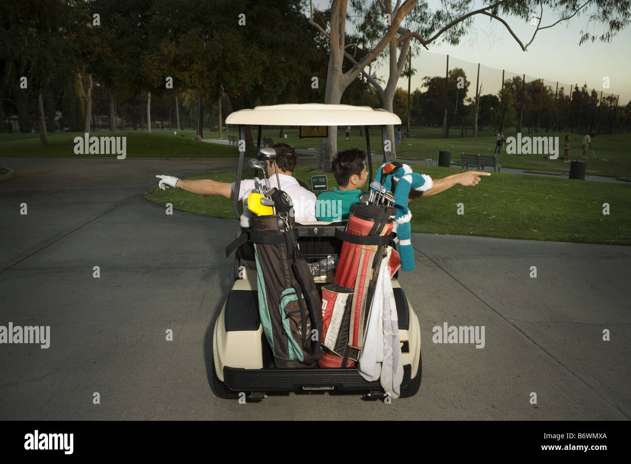 Two men having fun on golf cart Stock Photo - Alamy