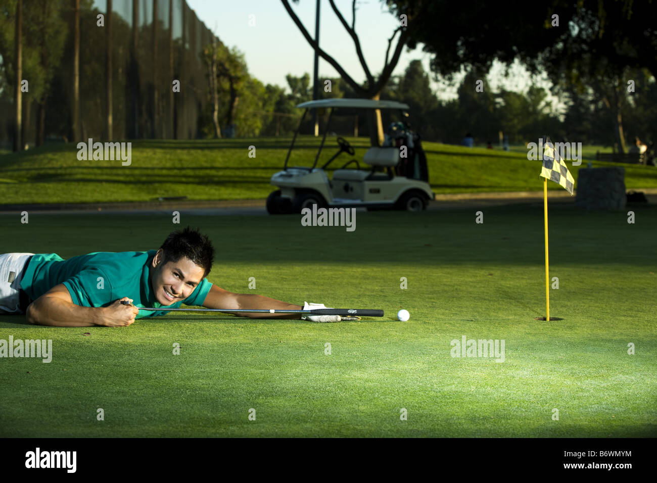Man pretending to play snooker on golf course Stock Photo - Alamy