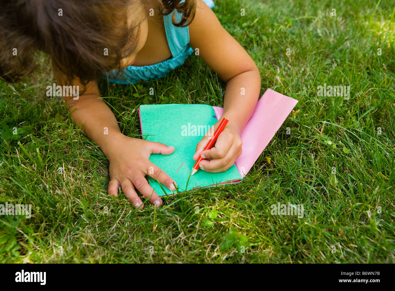 A girl writing in a book Stock Photo - Alamy