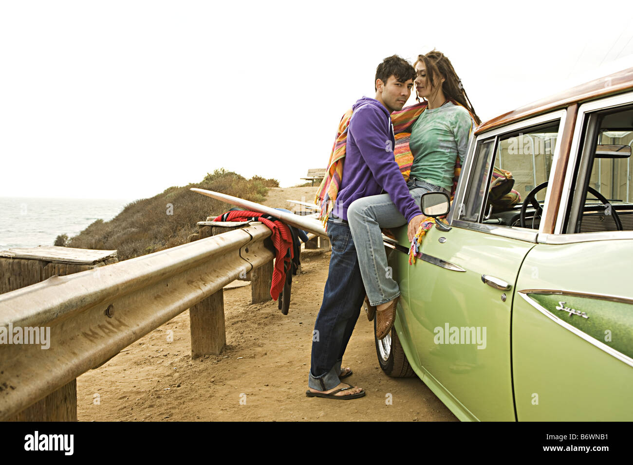 couple embrace on hoof of vintage car at beach Stock Photo - Alamy