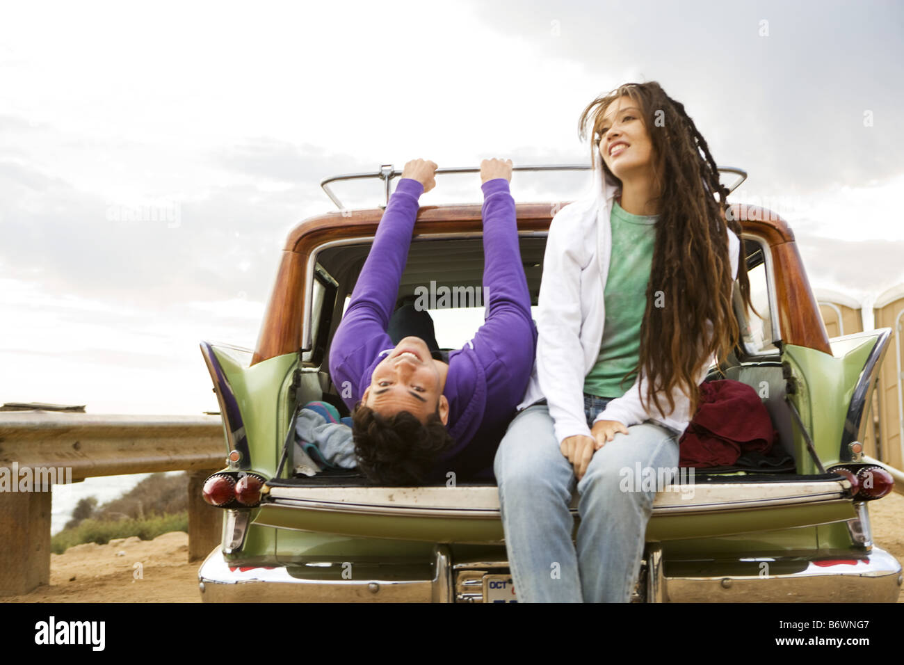 couple relax in back of vintage car at beach Stock Photo - Alamy