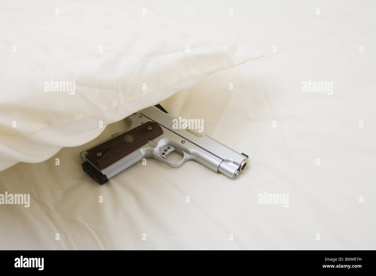 Handgun under a pillow Stock Photo - Alamy