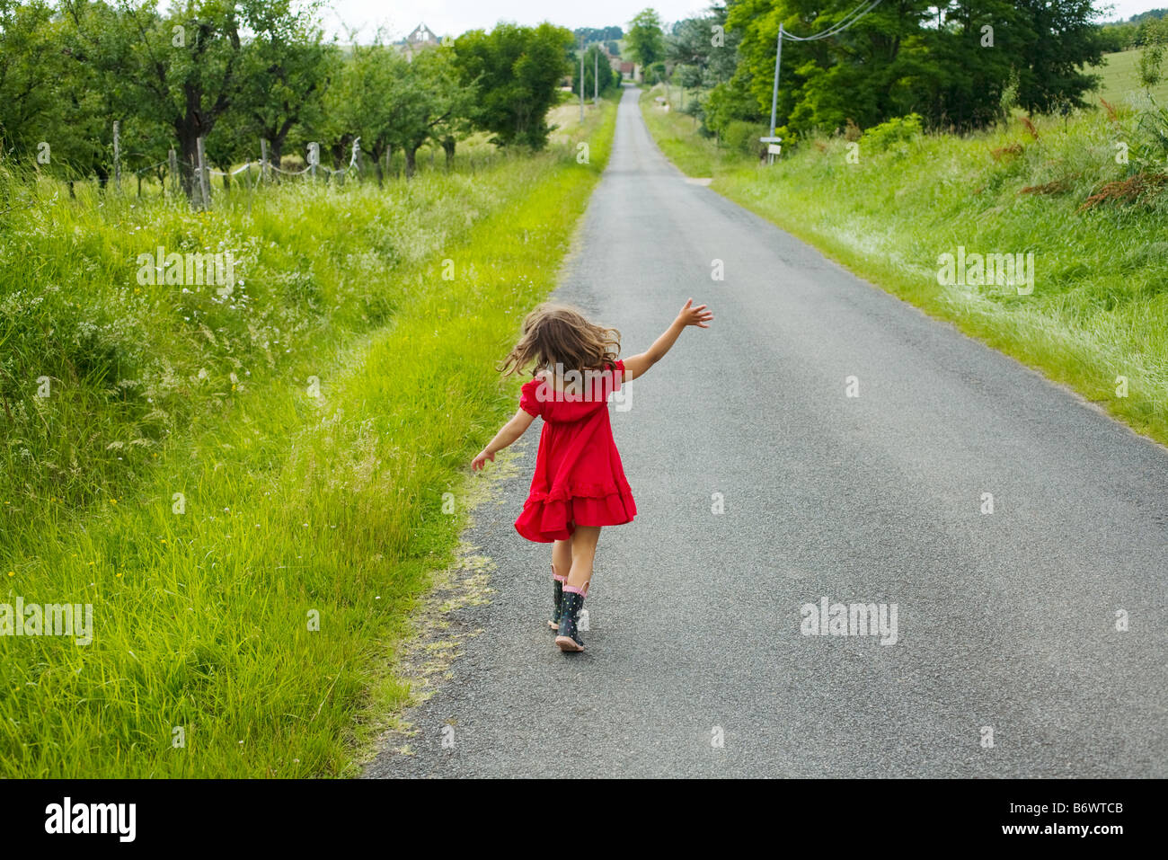 A girl skipping down a country road Stock Photo - Alamy