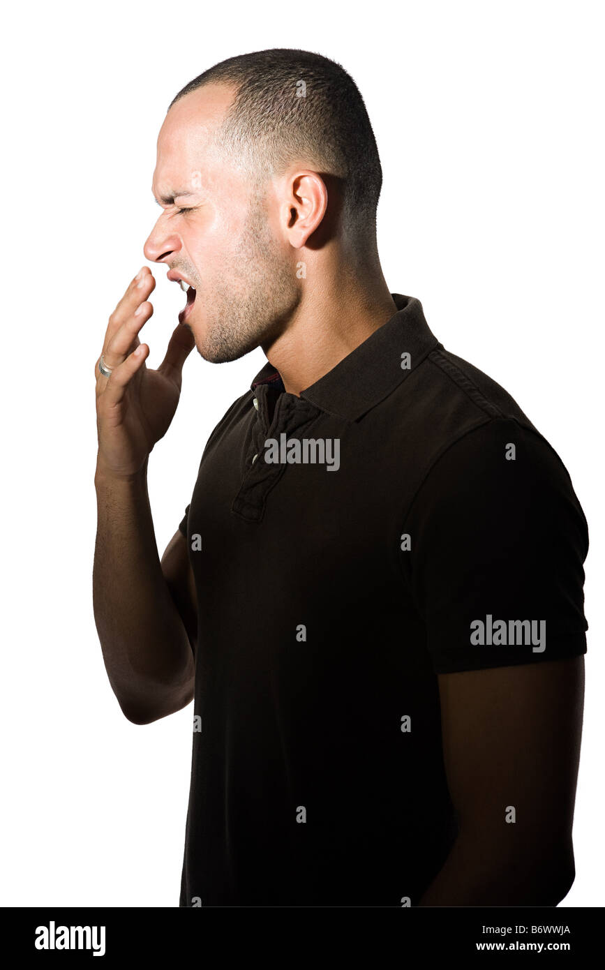 Young man yawning Stock Photo - Alamy