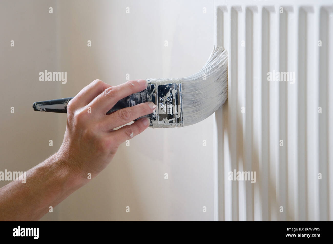 A man painting a radiator Stock Photo - Alamy