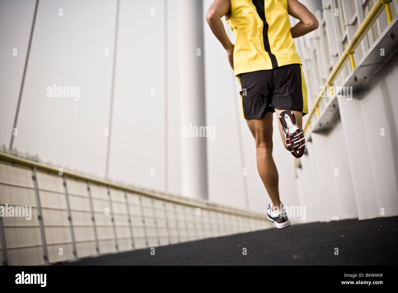 Man running across a bridge Stock Photo - Alamy