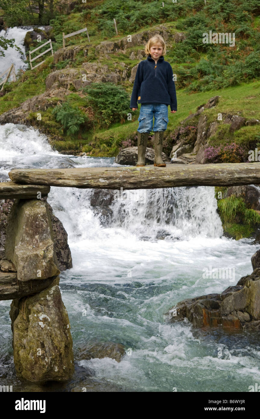 Wales, Conwy, Snowdonia. Child standing on a rustic bridge over the ...