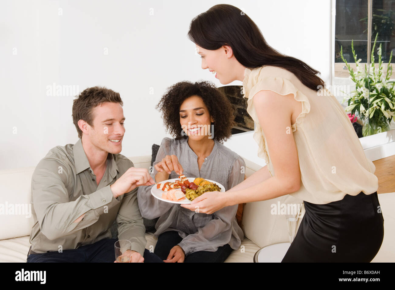 A woman offering friends canapes Stock Photo - Alamy
