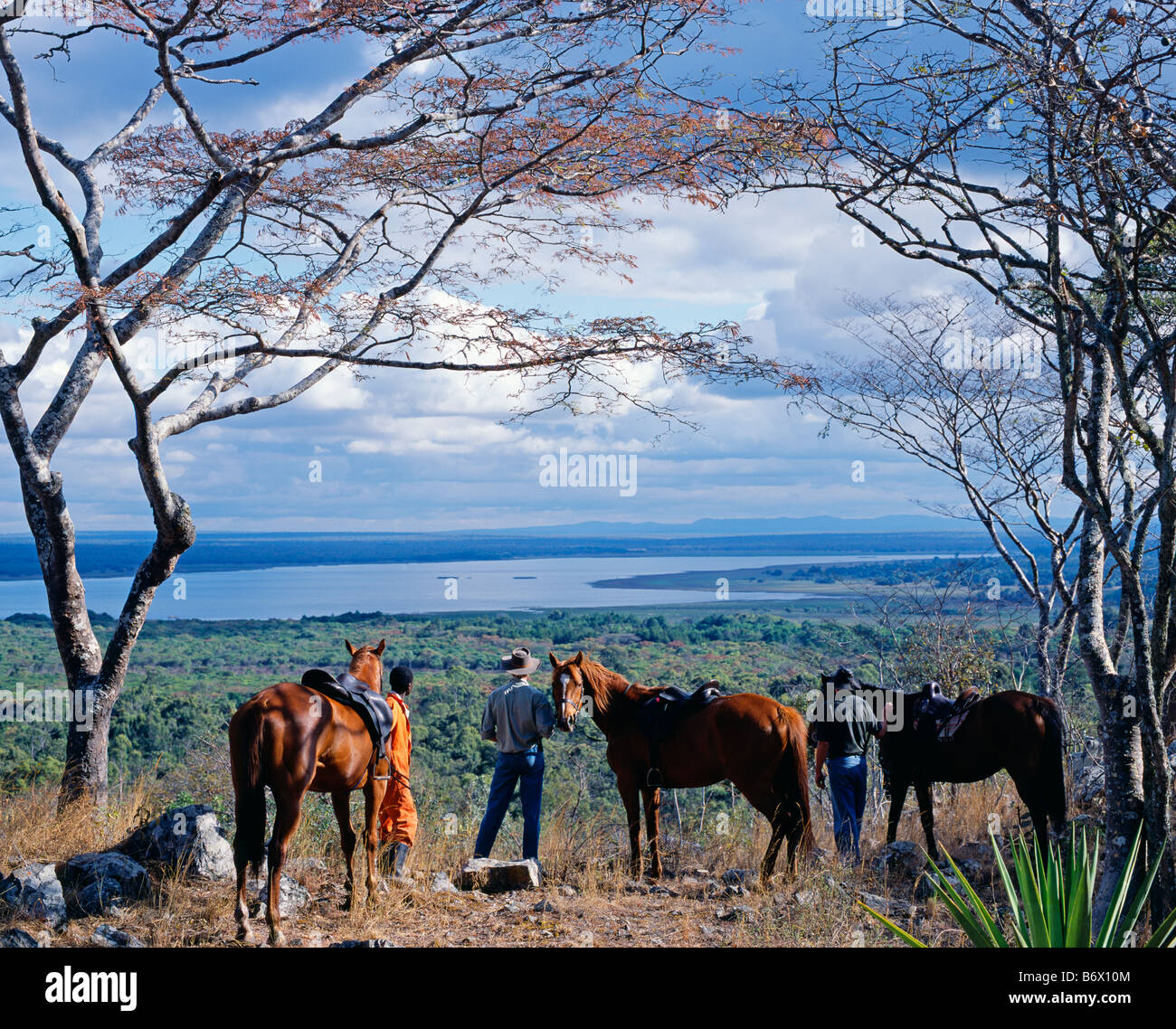 Zambia, Northern Province, Shiwa Ngandu. Riders looking out across Lake ...