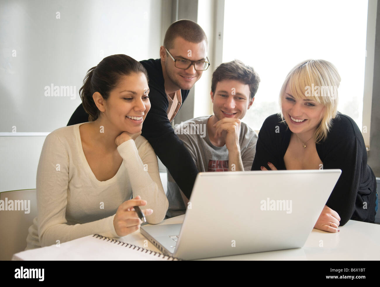 Classmates surrounding computer Stock Photo - Alamy