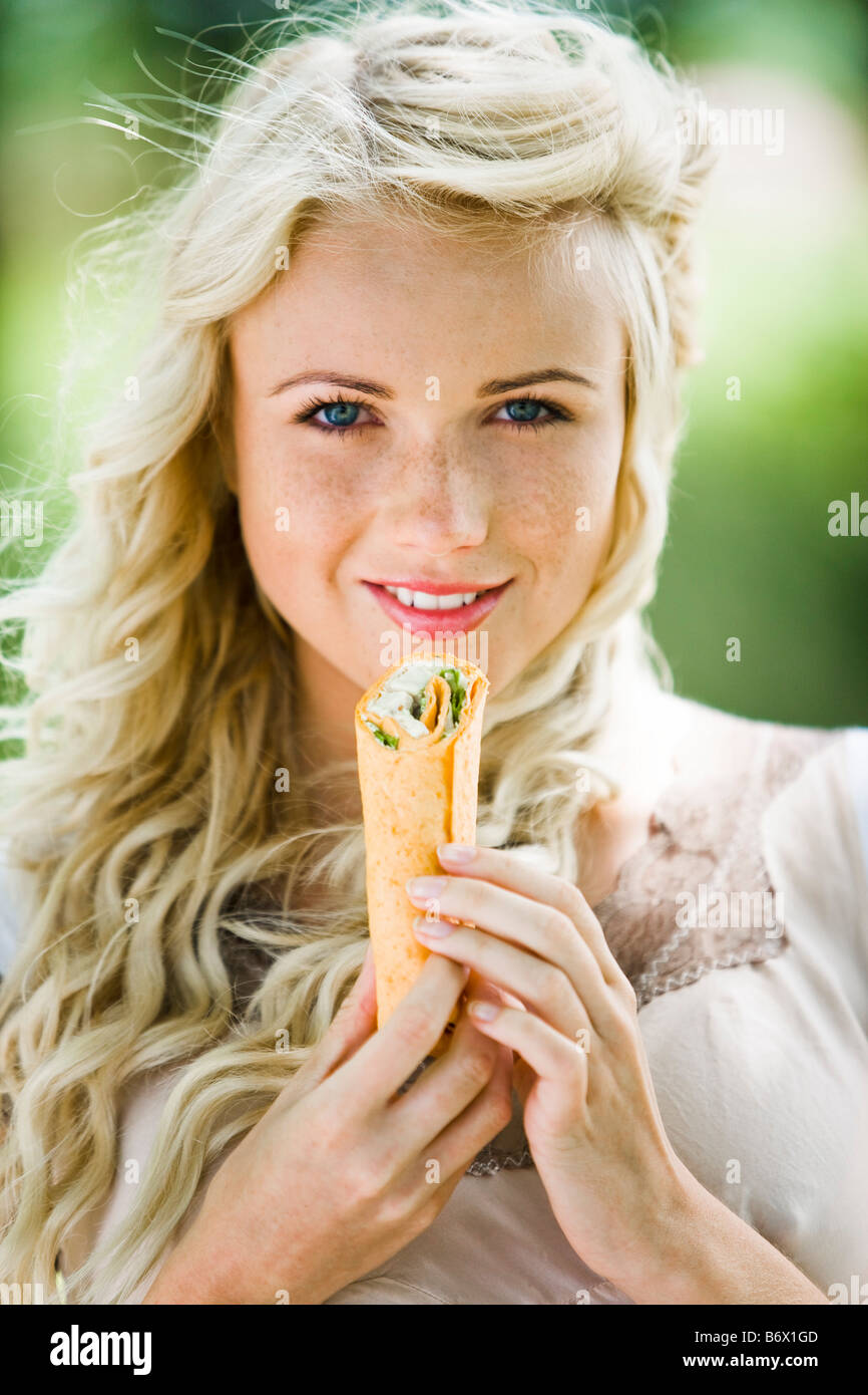 Young woman eating enchilada Stock Photo - Alamy