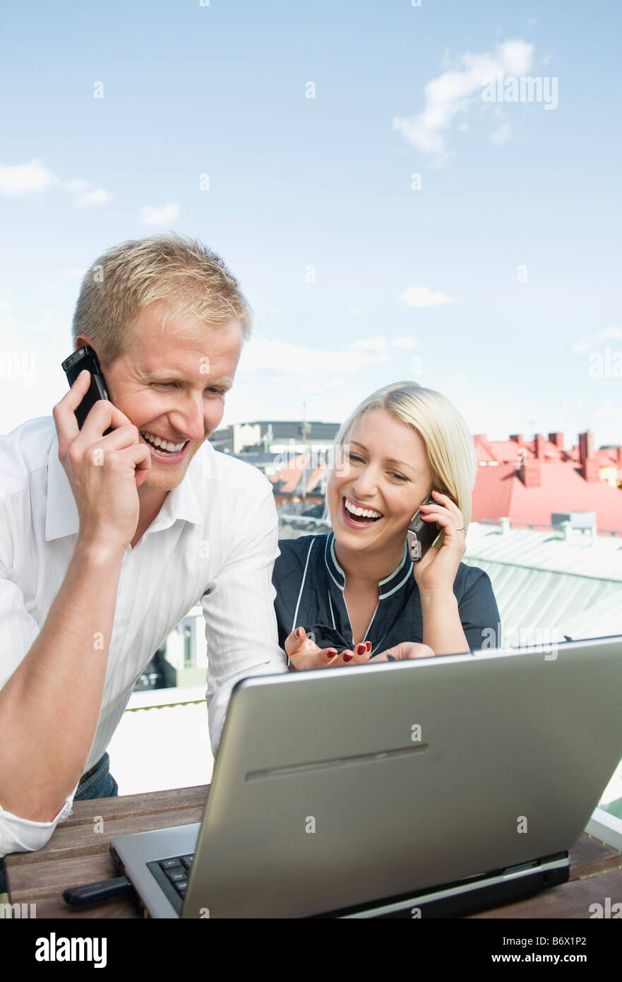 Guy and girl with computer and cellphone Stock Photo - Alamy