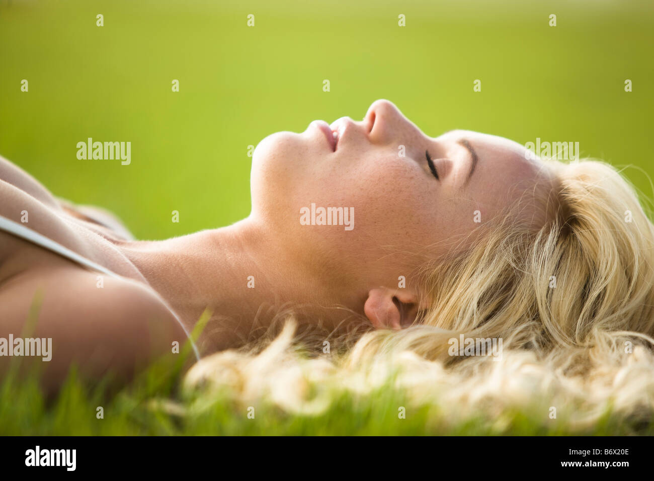 Woman lying on grass profile hi-res stock photography and images - Alamy