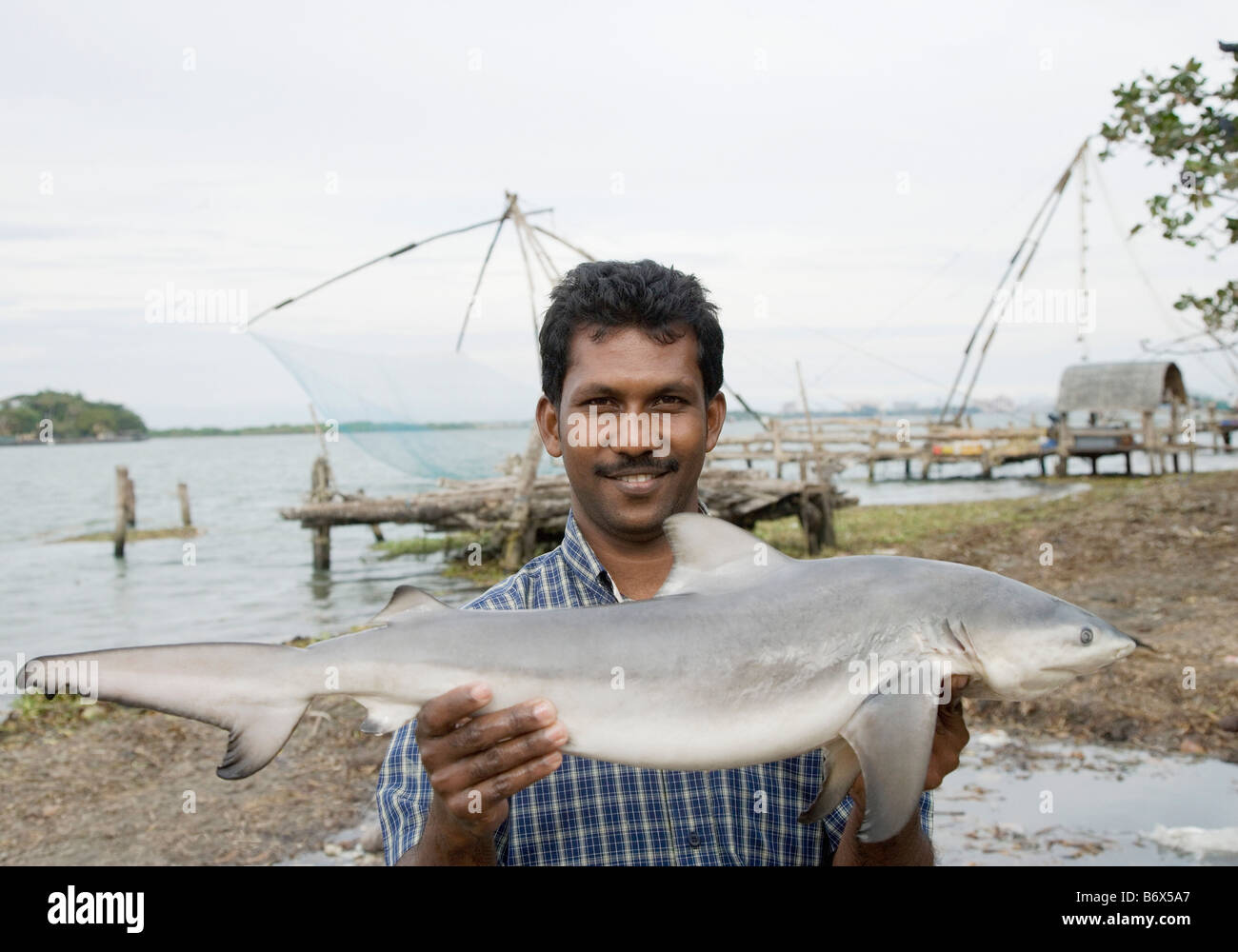 Fisherman showing a fish and smiling, Cochin, Kerala, India Stock Photo ...
