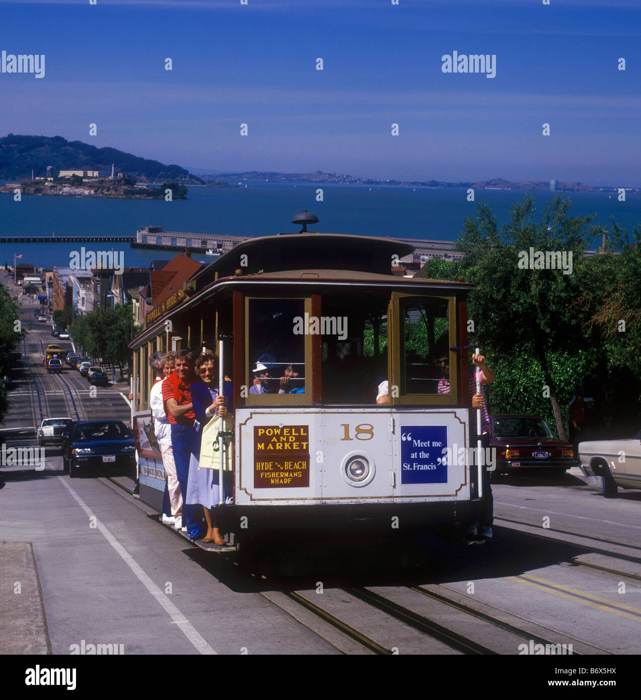 Cable car climbing a hill with a view showing the island of Alcatraz in ...