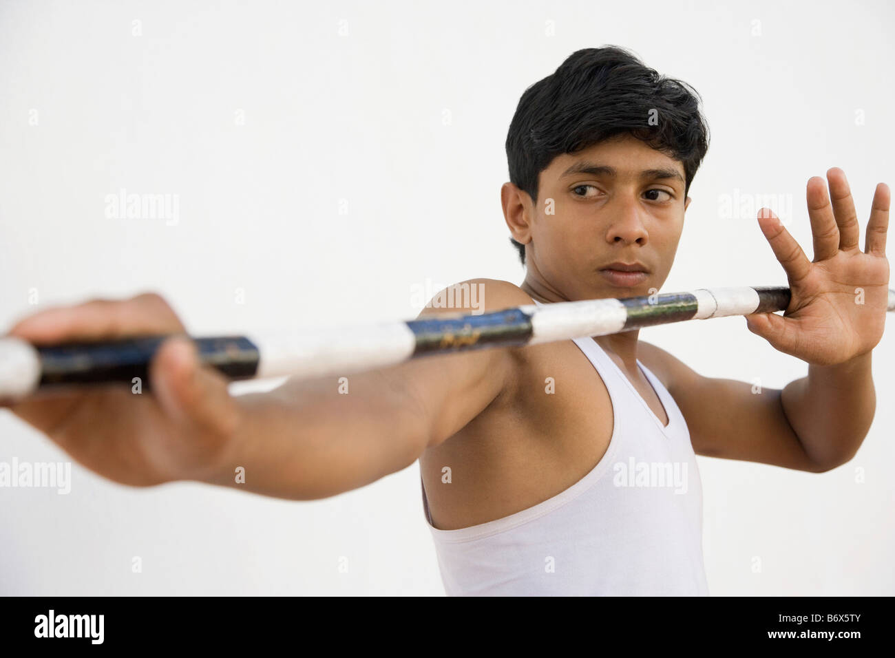 Close-up of a teenage boy holding a long staff Stock Photo - Alamy