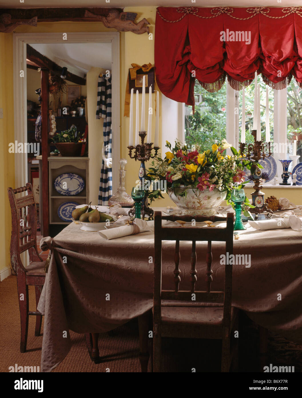 Red festoon blind on window in small cottage dining room with fresh ...
