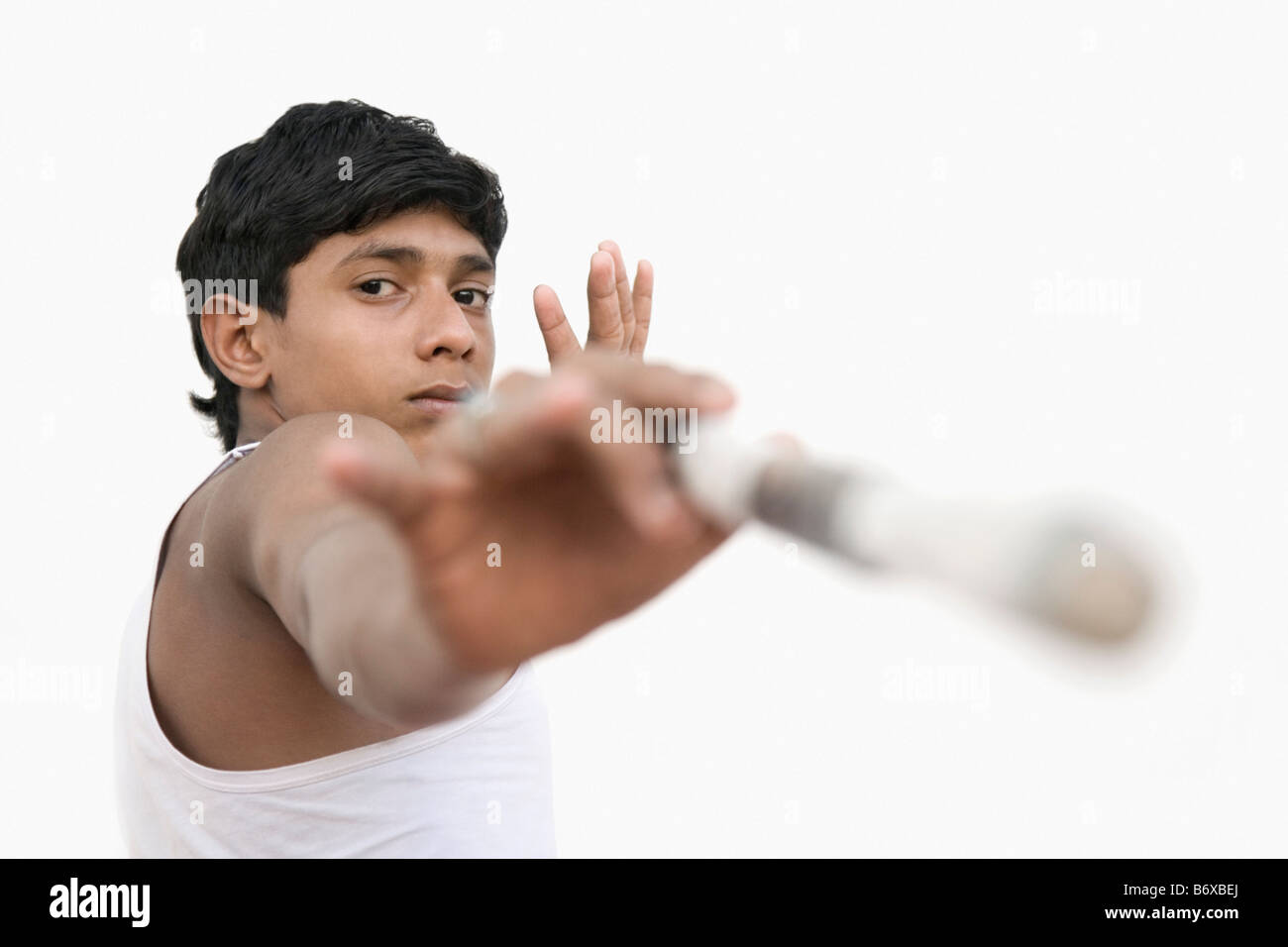 Portrait of a teenage boy holding a long staff Stock Photo - Alamy