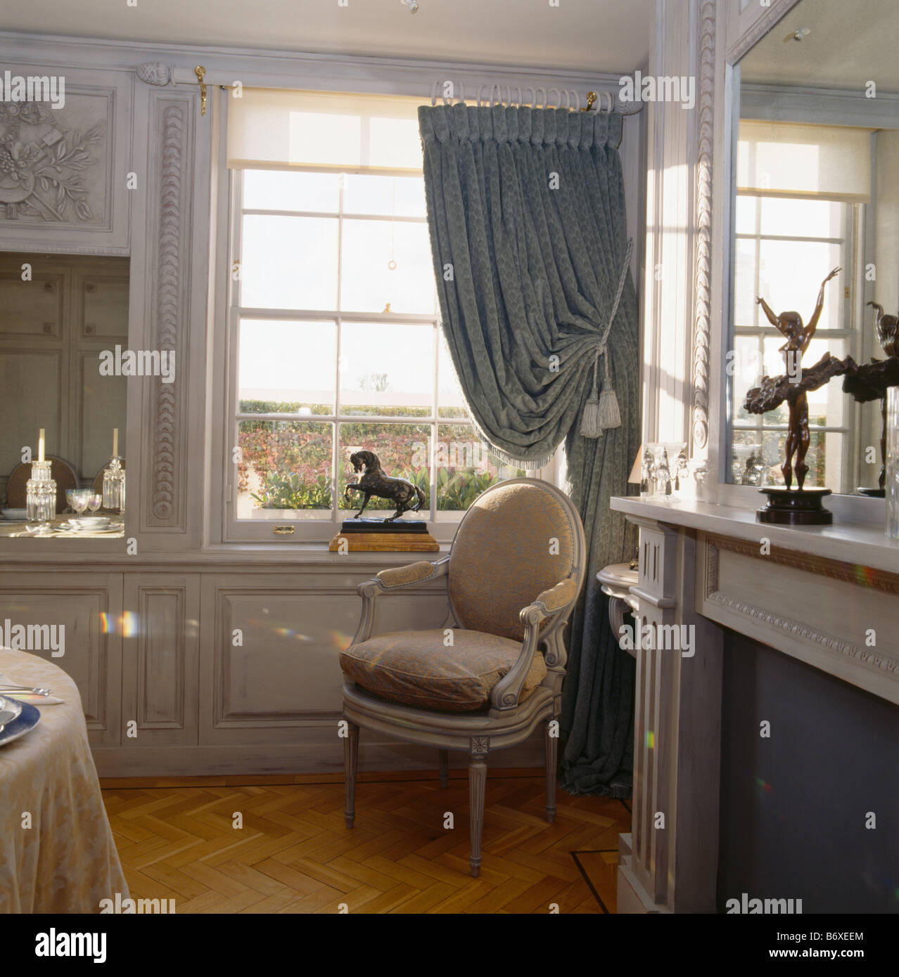Louis IV style chair in front of window with grey curtain in pale grey ...