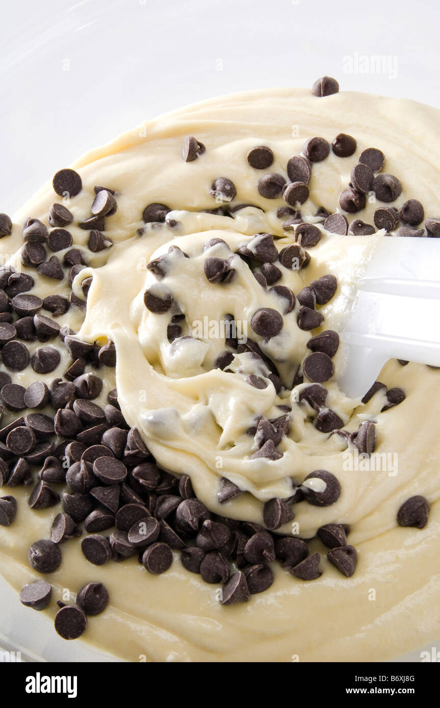 Mixing chocolate chips into raw cake mix. The batter mixture of eggs ...