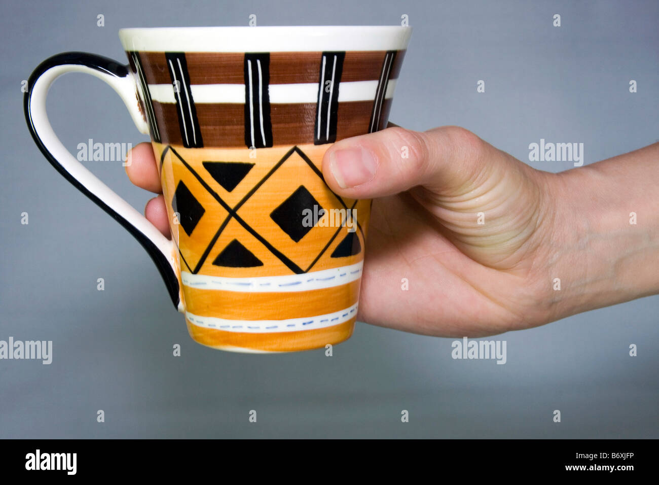 Hand holding the cup of tea Stock Photo - Alamy