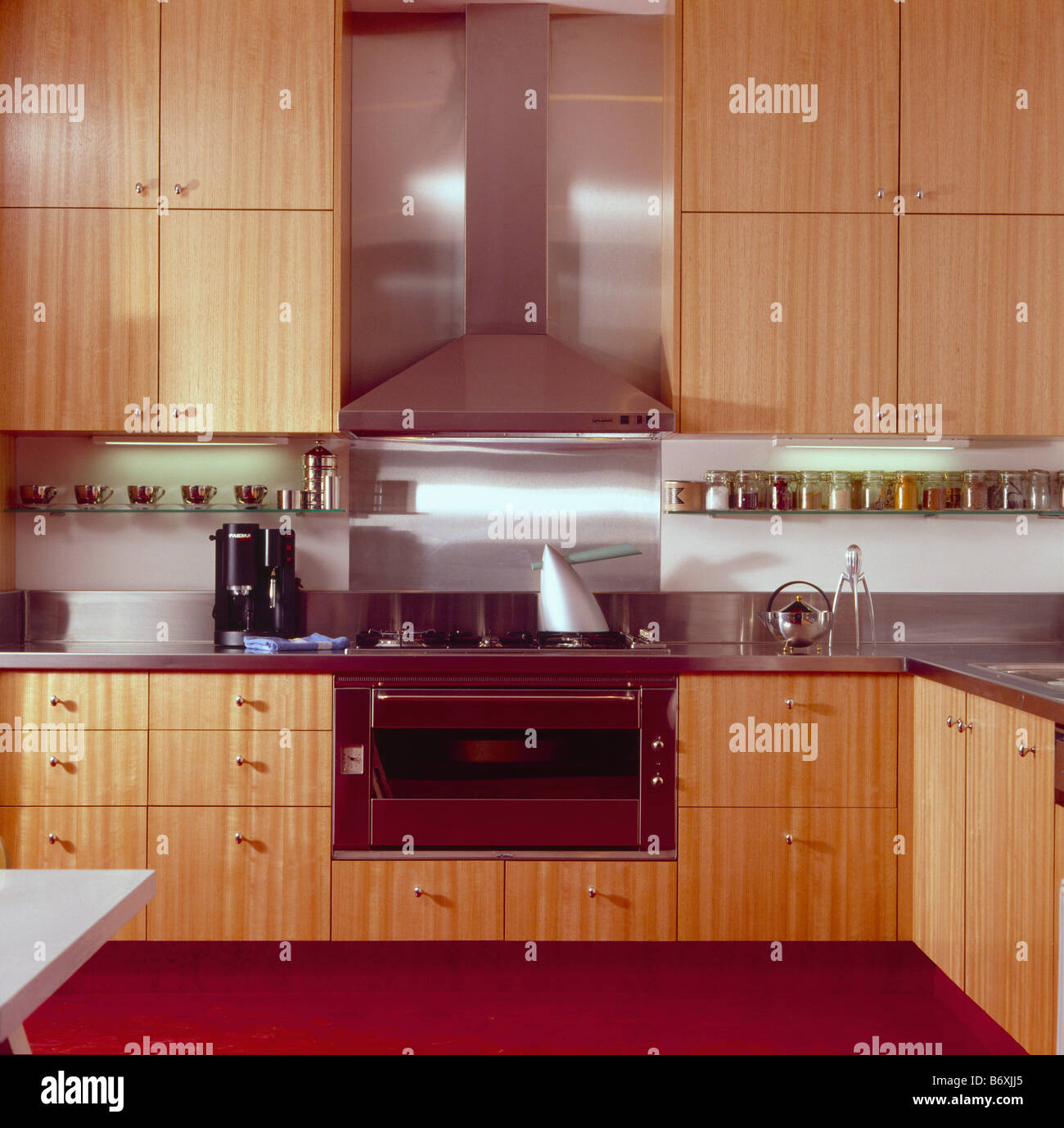 Stainless steel extractor above oven in modern kitchen with pale wood ...