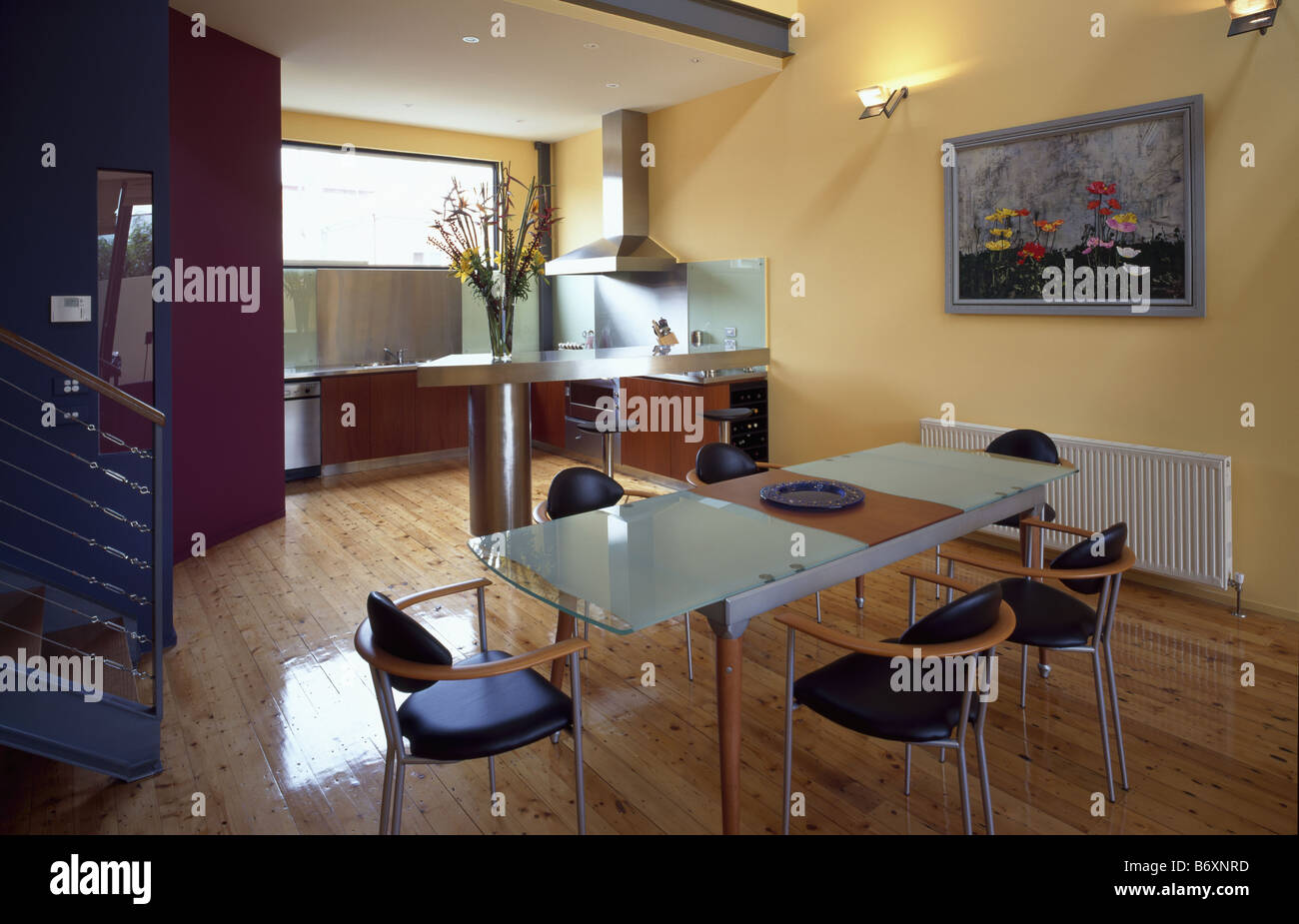 Glass-topped table in large modern yellow kitchen dining room with ...