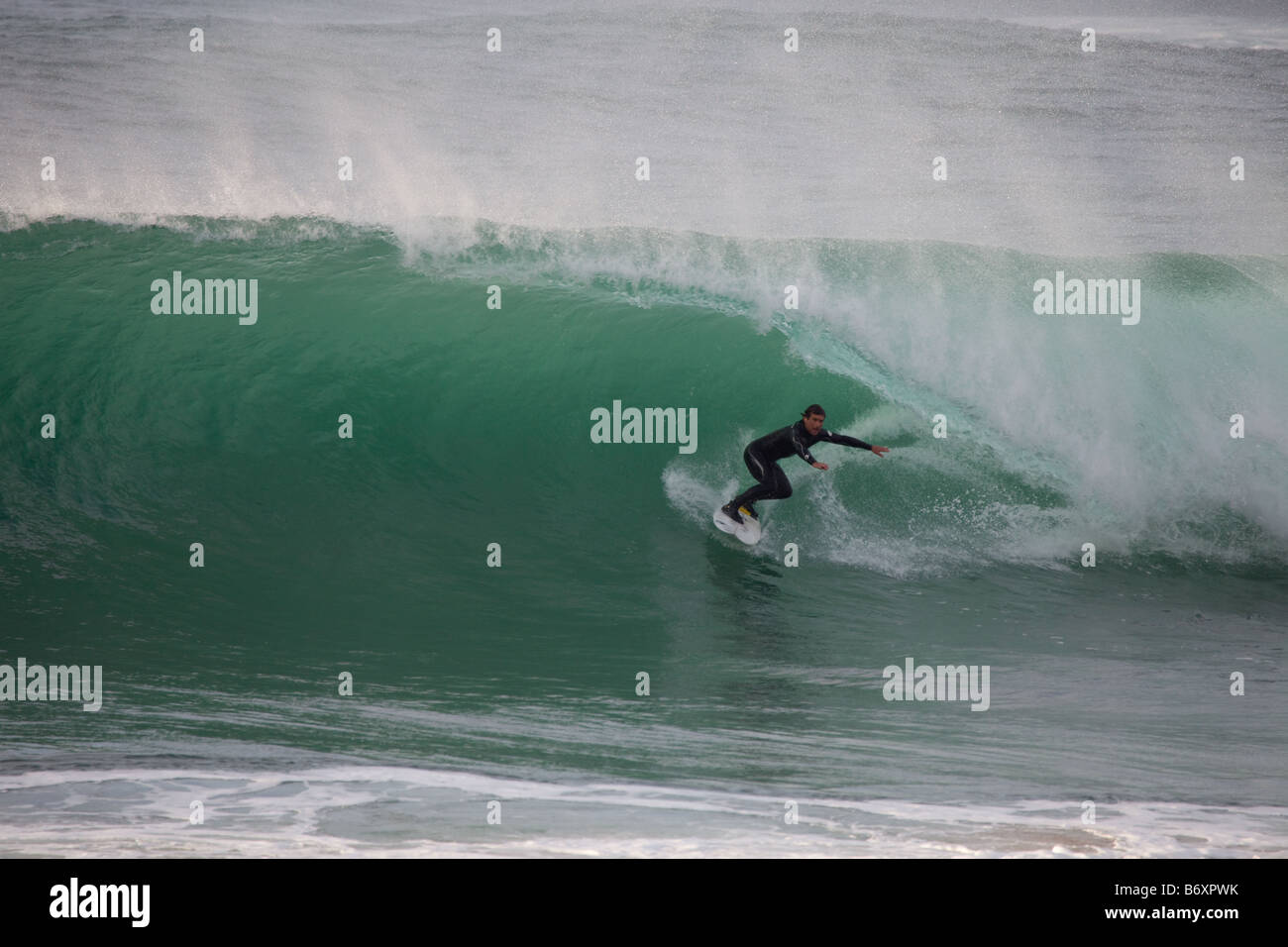 Surfer running away from a close out wave at Guincho Beach, Portugal ...