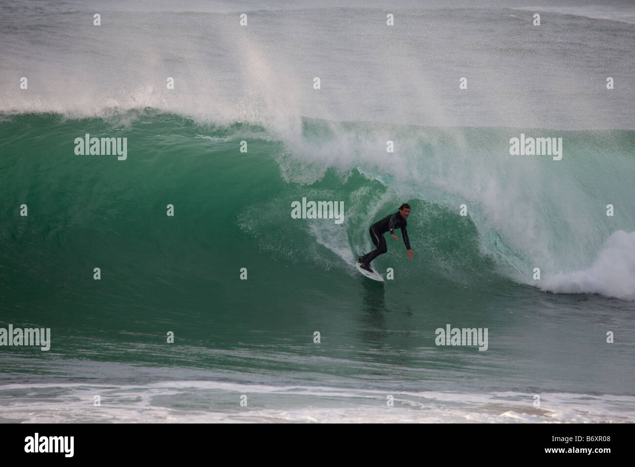 Surfer running away from a close out wave at Guincho Beach, Portugal ...