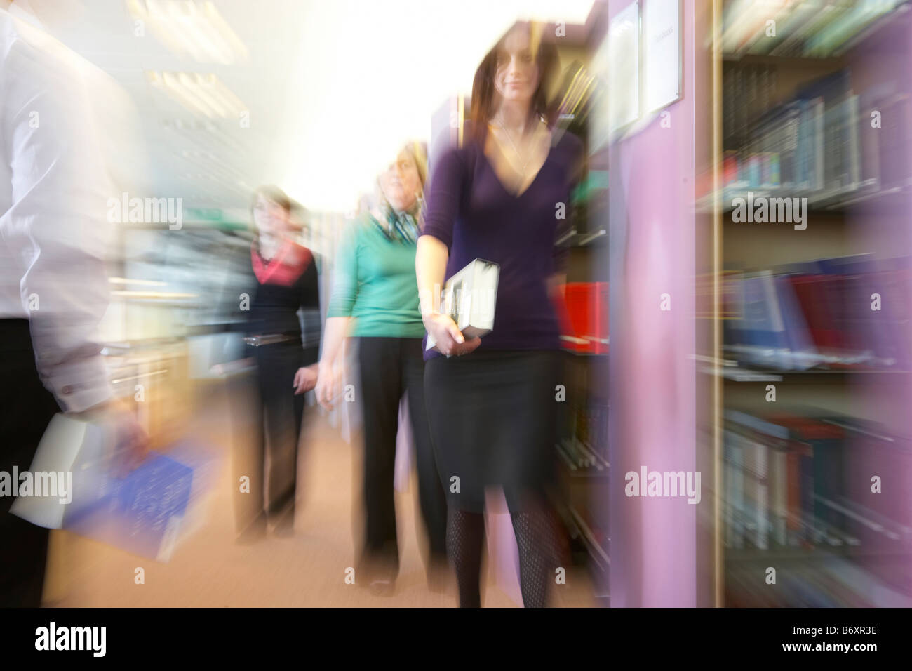 Woman walking with book Stock Photo - Alamy