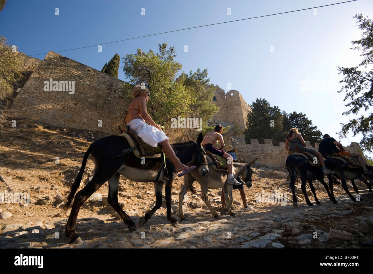 Tourists riding on donkeys to Acropolis, Lindos, Rhodes, Greece Stock ...