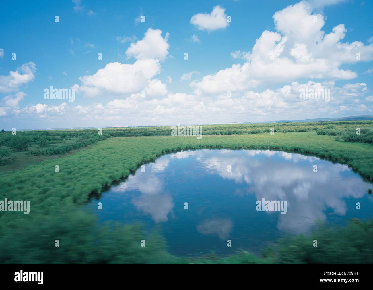 Plain with pond under sky Stock Photo - Alamy