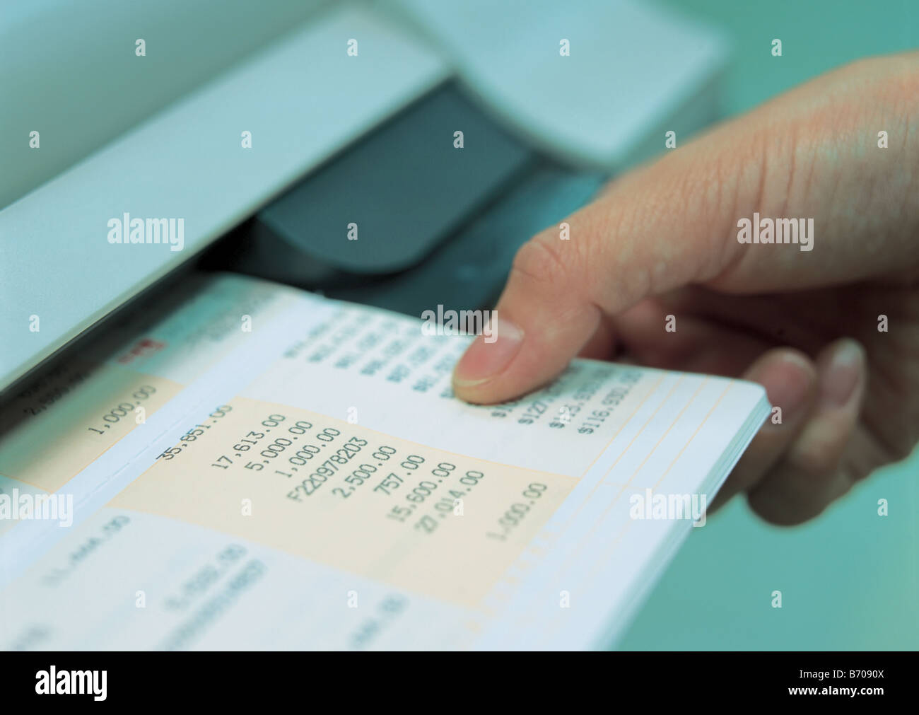 A hand holding bankbook is using passbook entry machine Stock Photo - Alamy