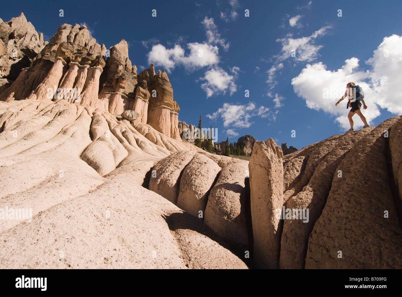 Woman hiking through volcanic towers, Wheeler Geologic Area, Rio Grande ...