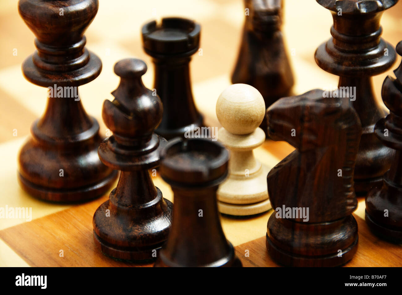 white pawn chessman surrounded by black pieces concept surrounded Stock ...