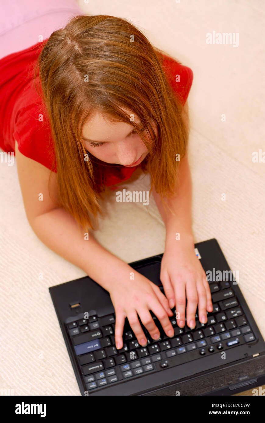 Young girl lying on the floor with portable computer Stock Photo - Alamy