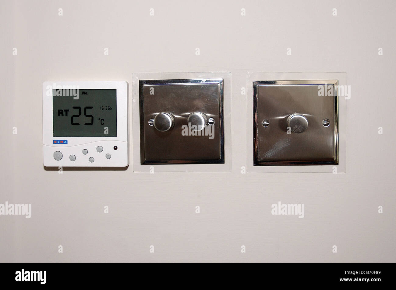 Close-up of central heating controls and metallic light switches Stock ...