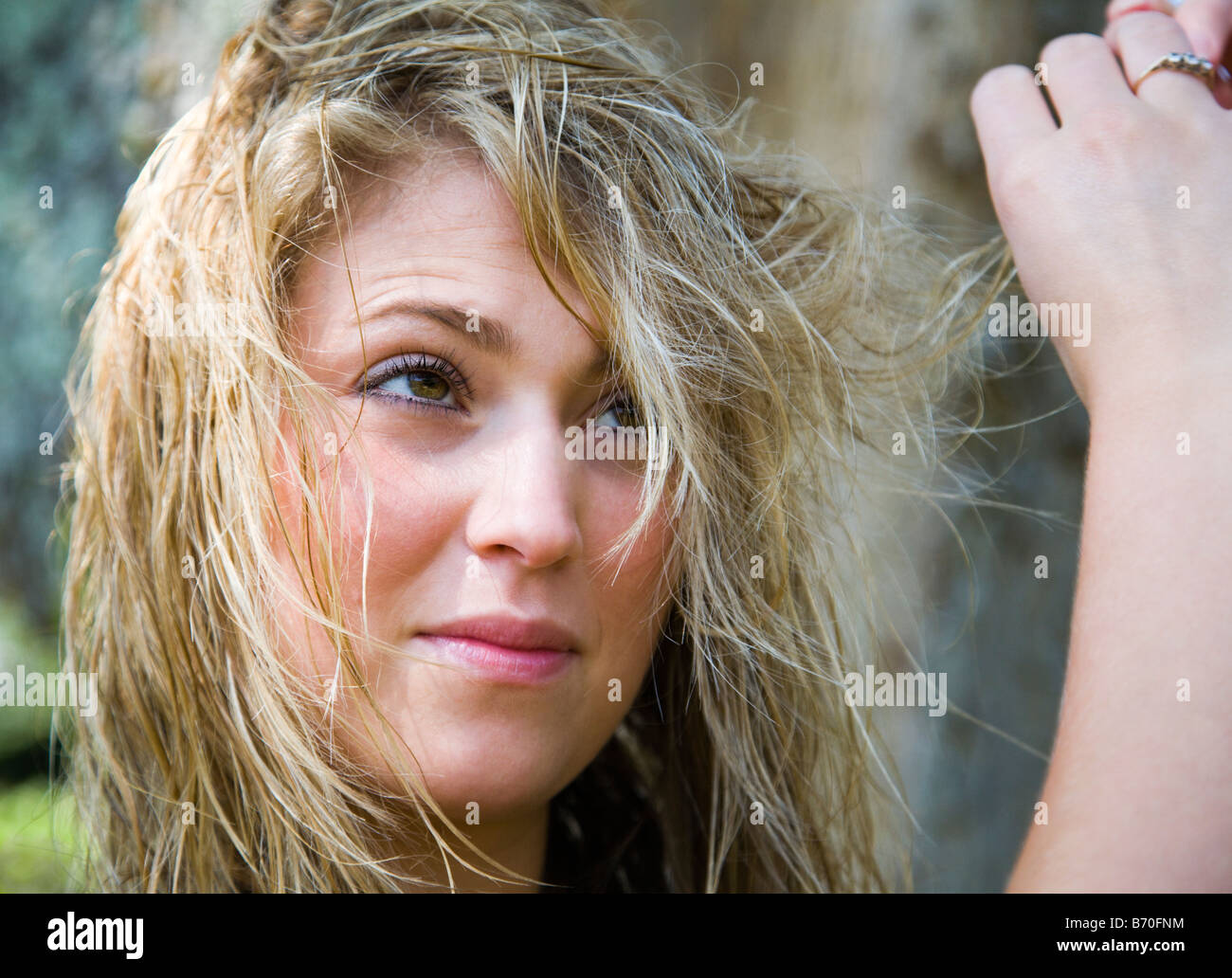 Young woman checking for split ends. Having a bad hair day Stock Photo ...
