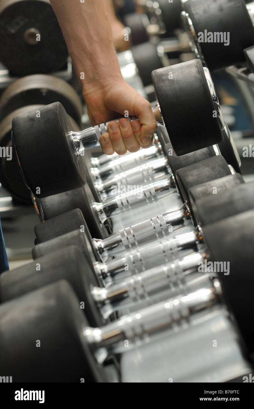 Row of dumbells with hand hi-res stock photography and images - Alamy