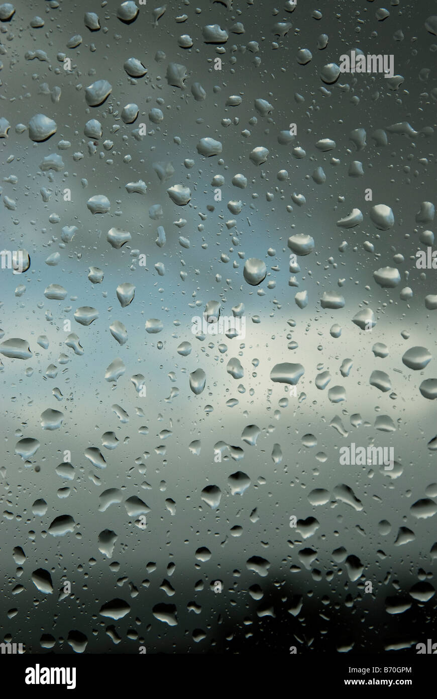 Big raindrops on window with storm clouds behind Stock Photo - Alamy