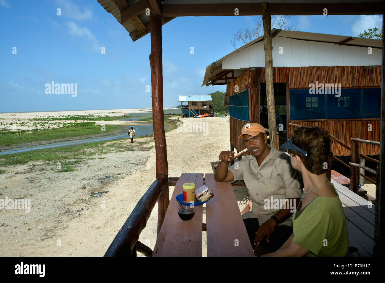 Suriname, Matapica National Park. Tourist talking with local manager of ...