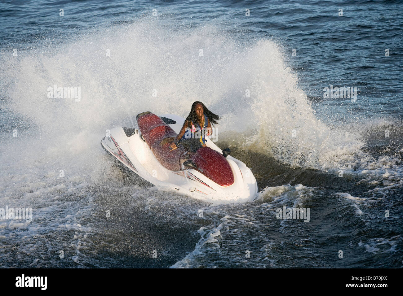 Suriname, White Beach, south of Paramaribo. Woman on water scooter ...