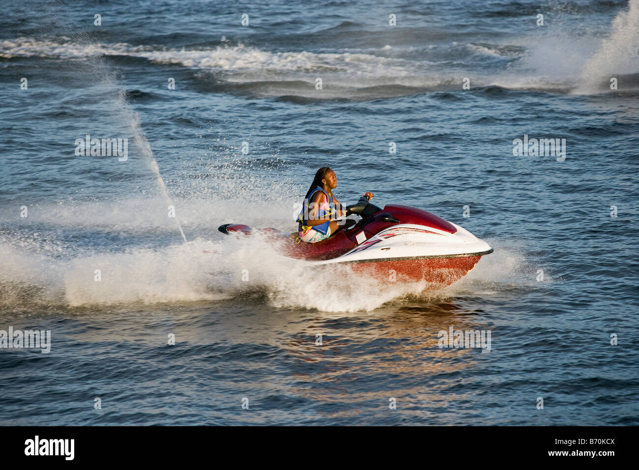 Suriname, White Beach, south of Paramaribo. Woman on water scooter ...