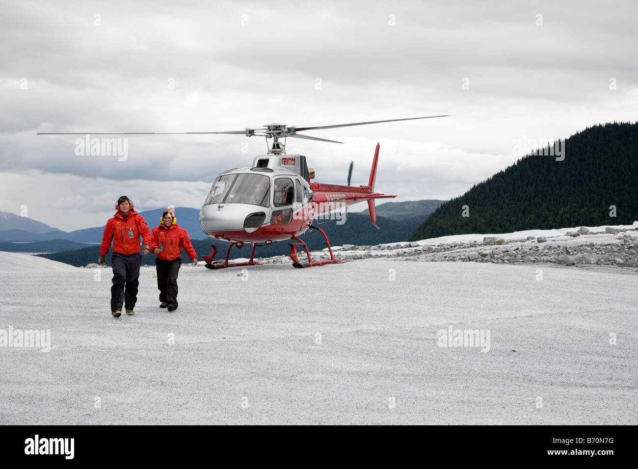 Helicopter tour guides walk from helicopter on top of Mendenhall ...