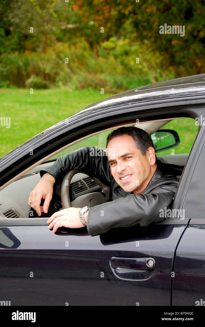 Smiling happy man looking from a car window Stock Photo - Alamy