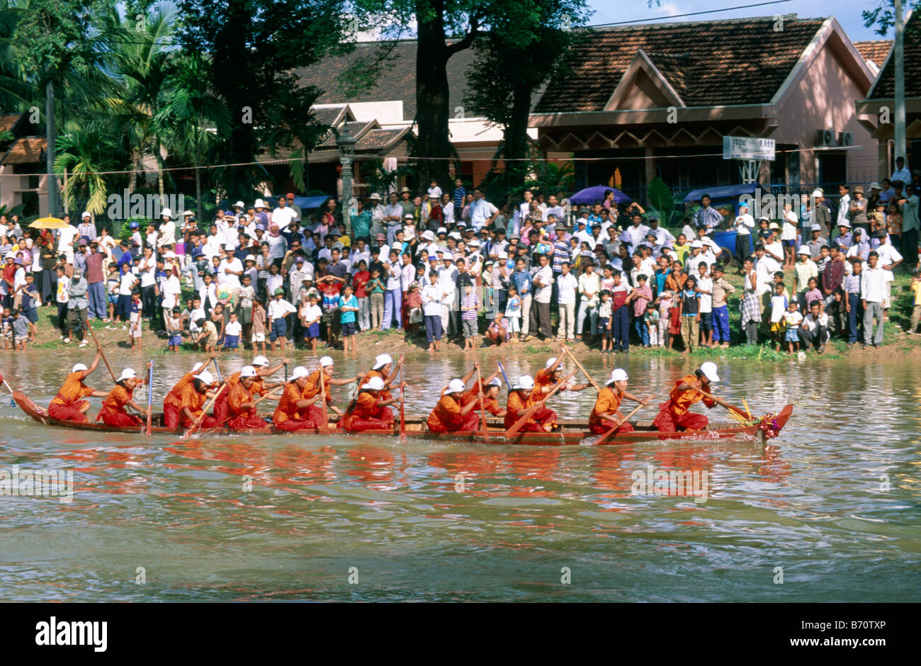 River Dragon boat racing Team of women in red shirts Crowd on bank ...
