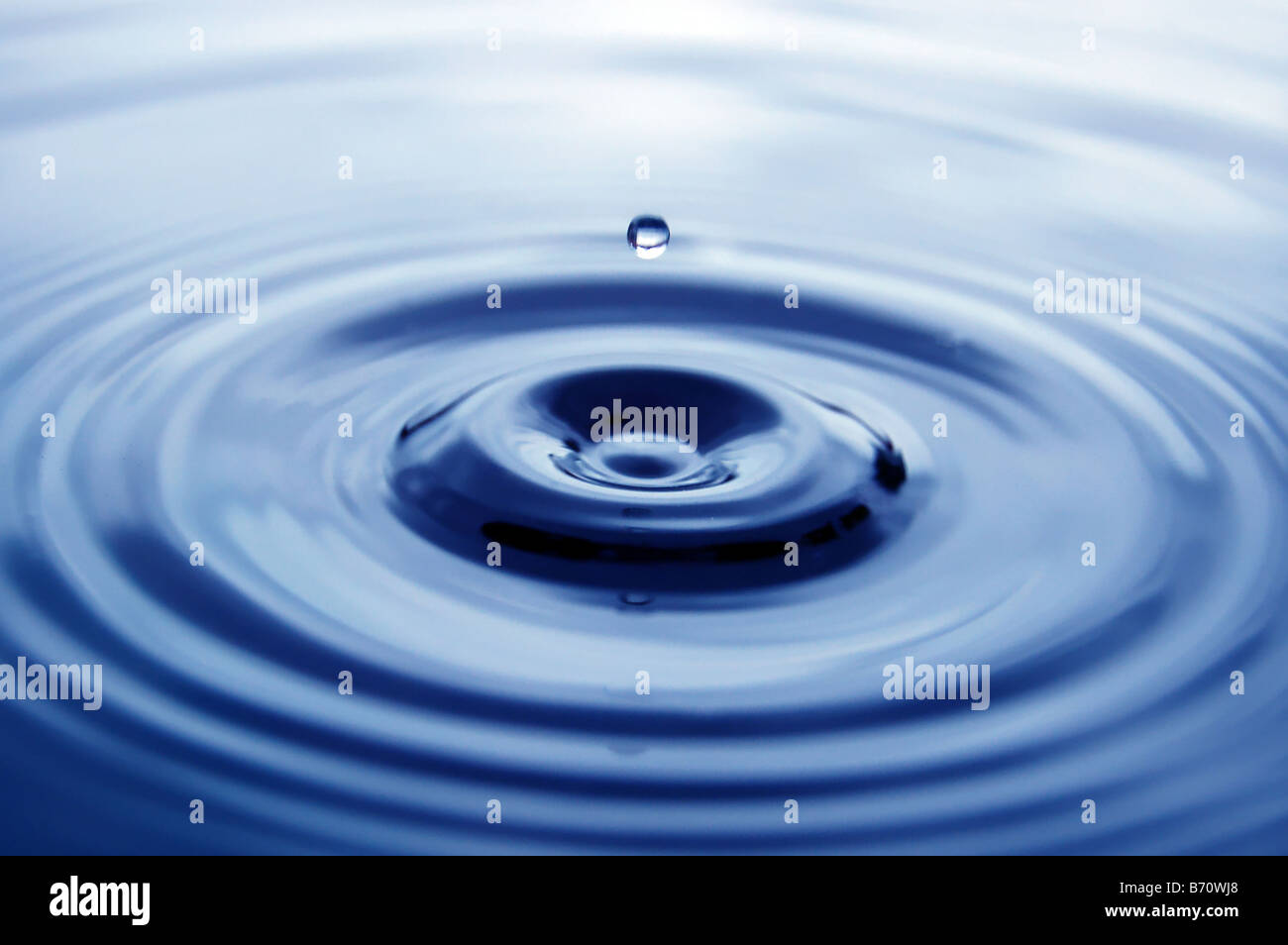 A drop of water above water surface water splash Stock Photo - Alamy