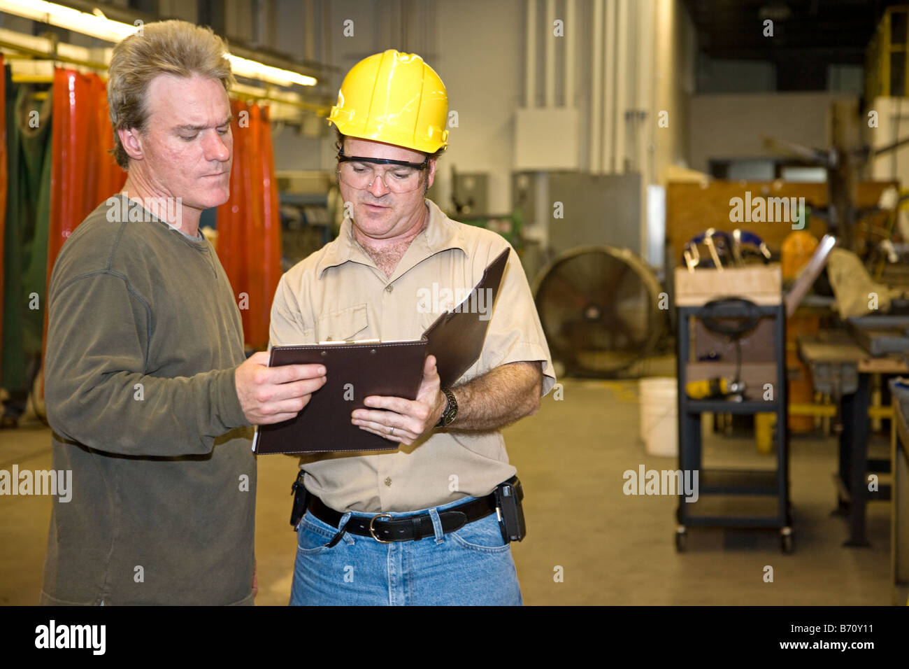 Industrial auditor discussing his inspection results with the factory ...