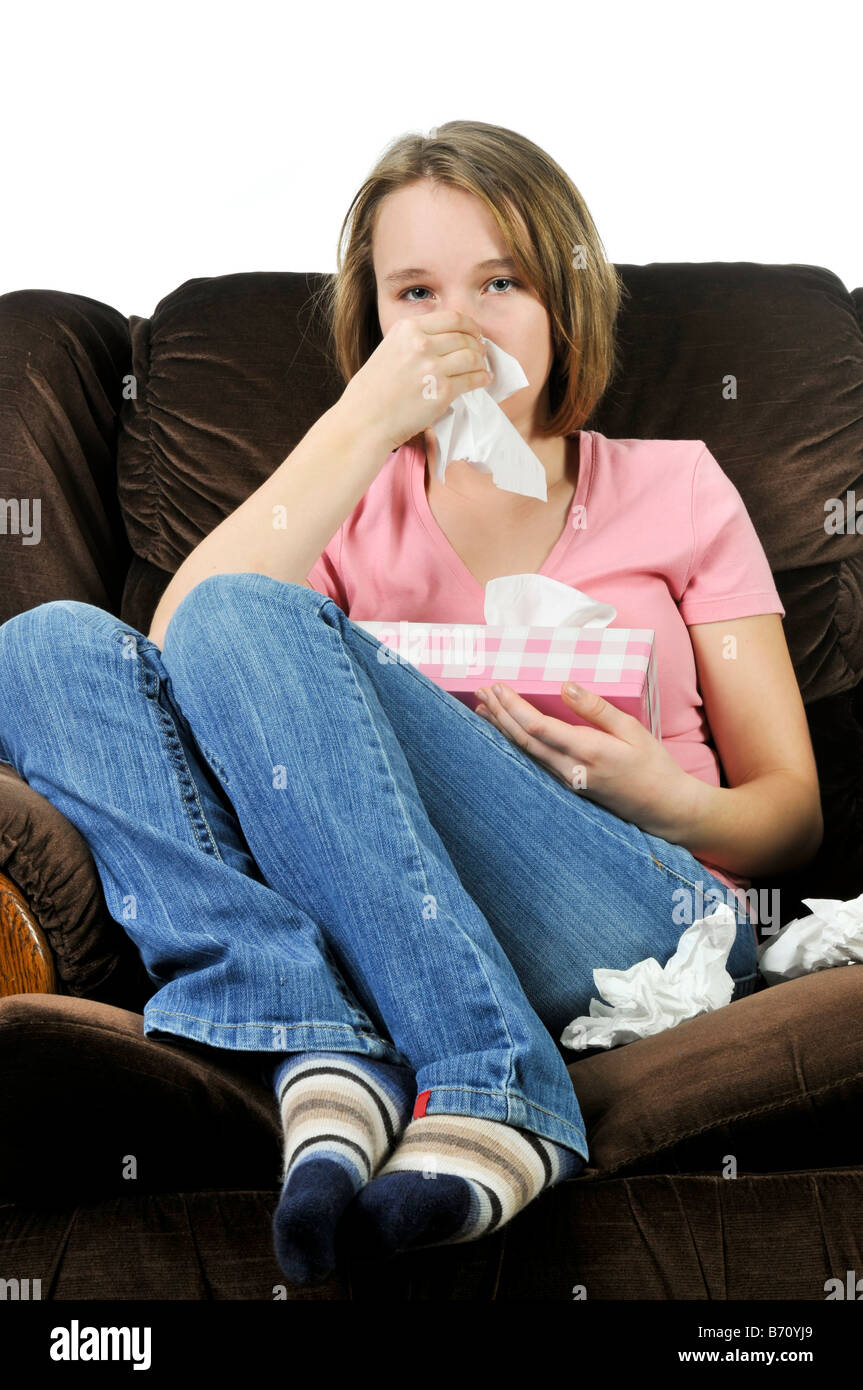 Teenage girl with a cold sitting in a chair with tissue box Stock Photo ...